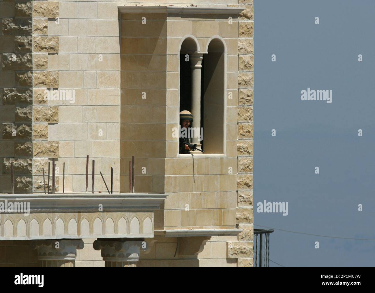 An Israeli soldier stands guard at the window of a Lebanese house in ...