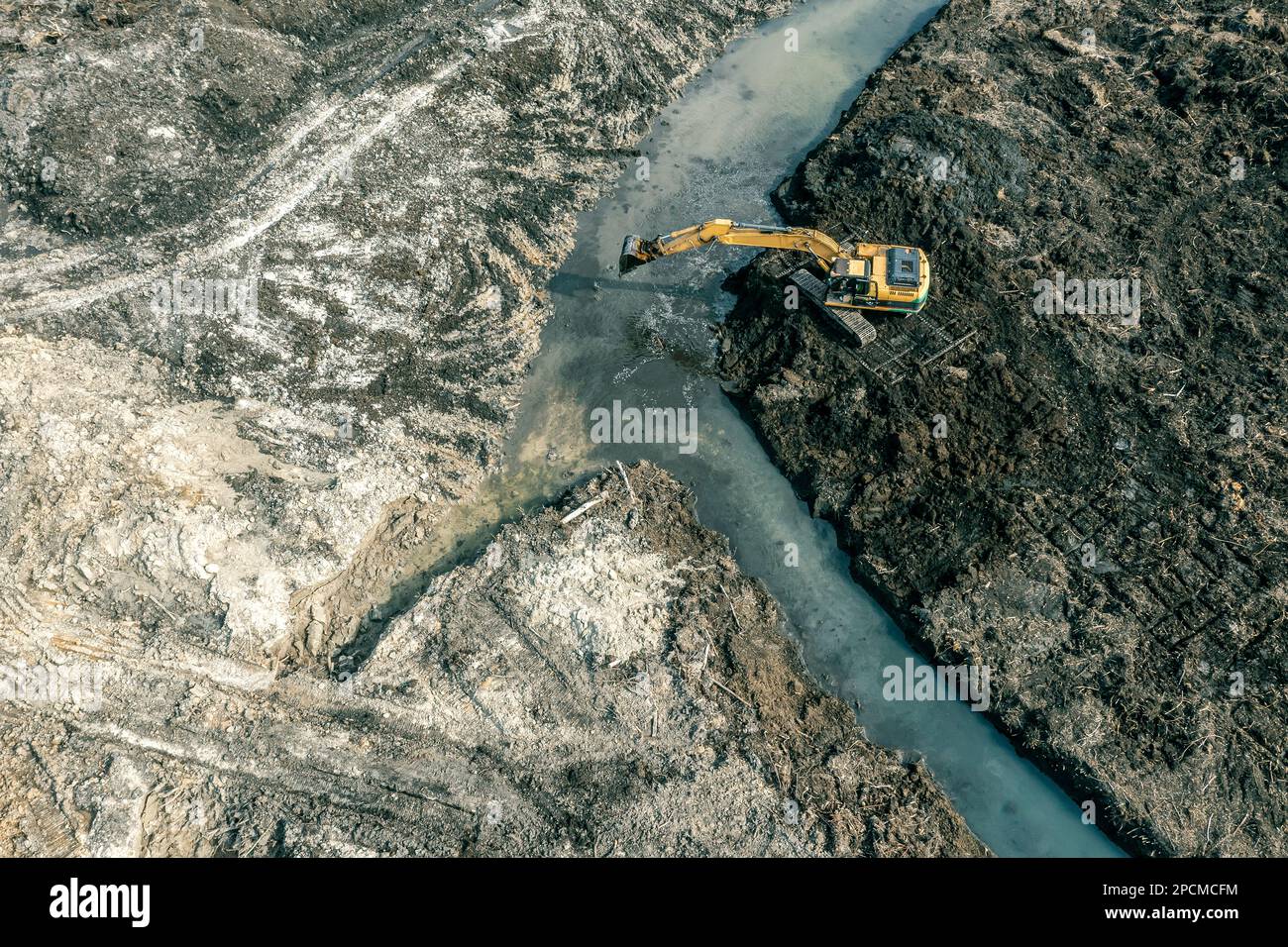 big powerful excavator digging drainage ditch in swampy countryside ...