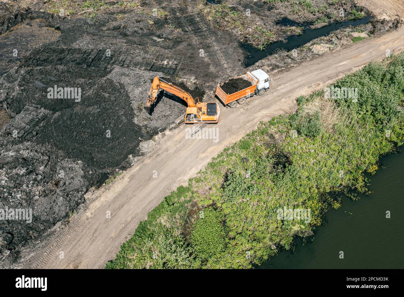 aerial view of an backhoe and truck on earthworks. marshy area ...