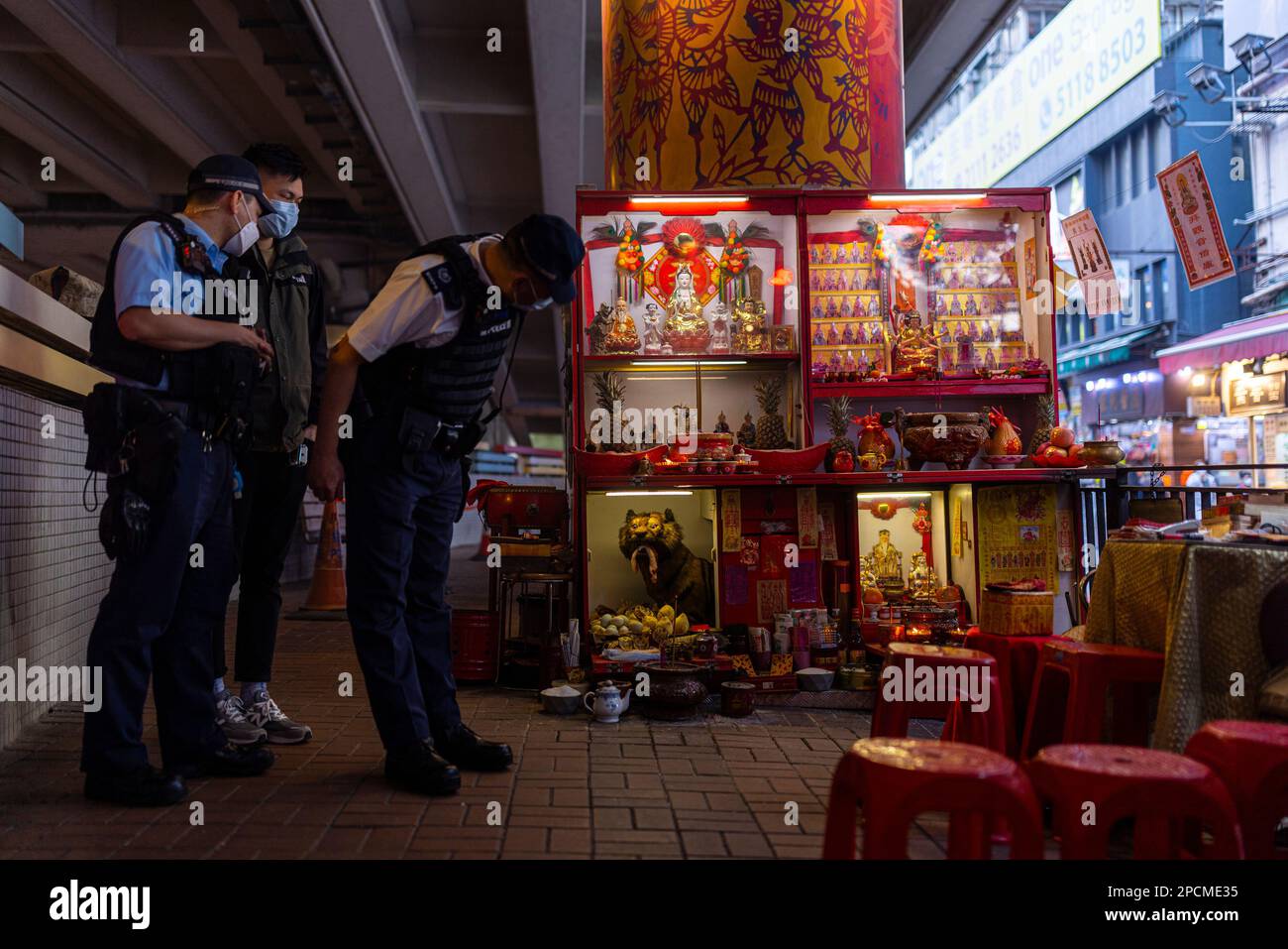 Police officers and a plainclothes police officer inspect a "villain ...