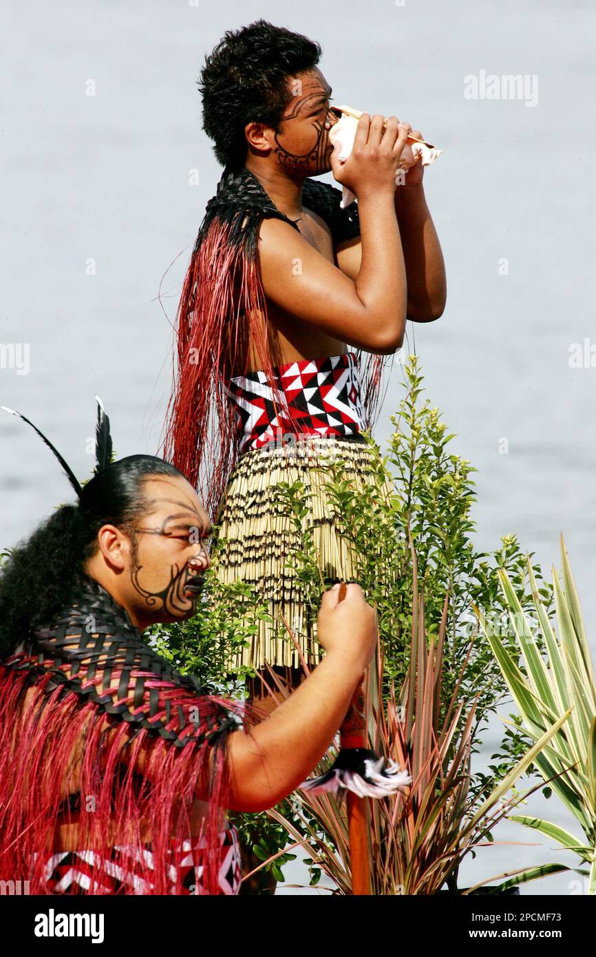 Maori warriors with moko (facial tattoos), one blowing a conch shell ...