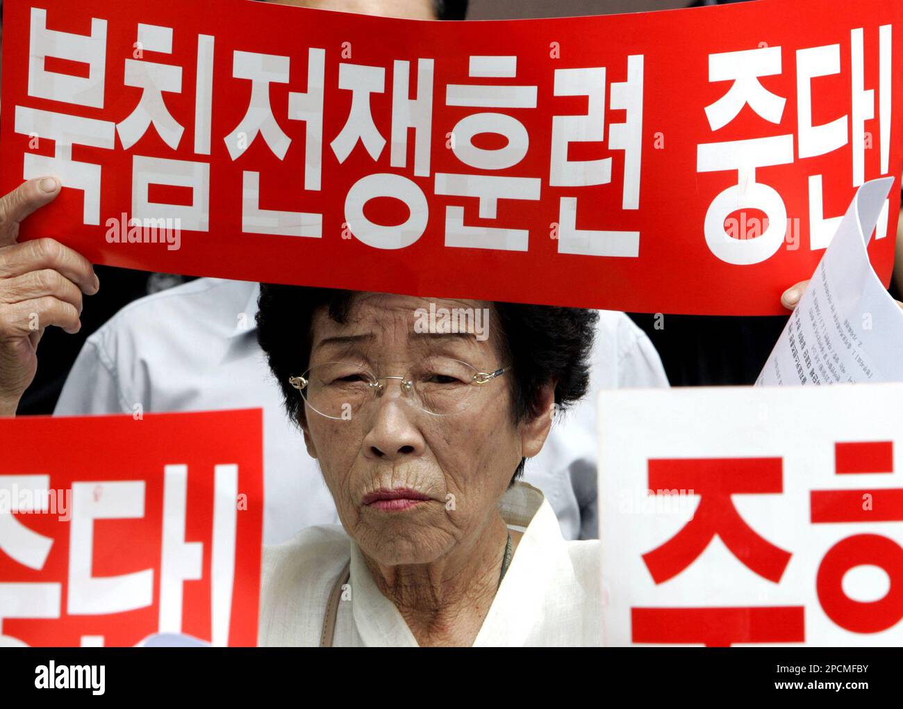 A South Korean protester flashes a placard during a rally against South ...