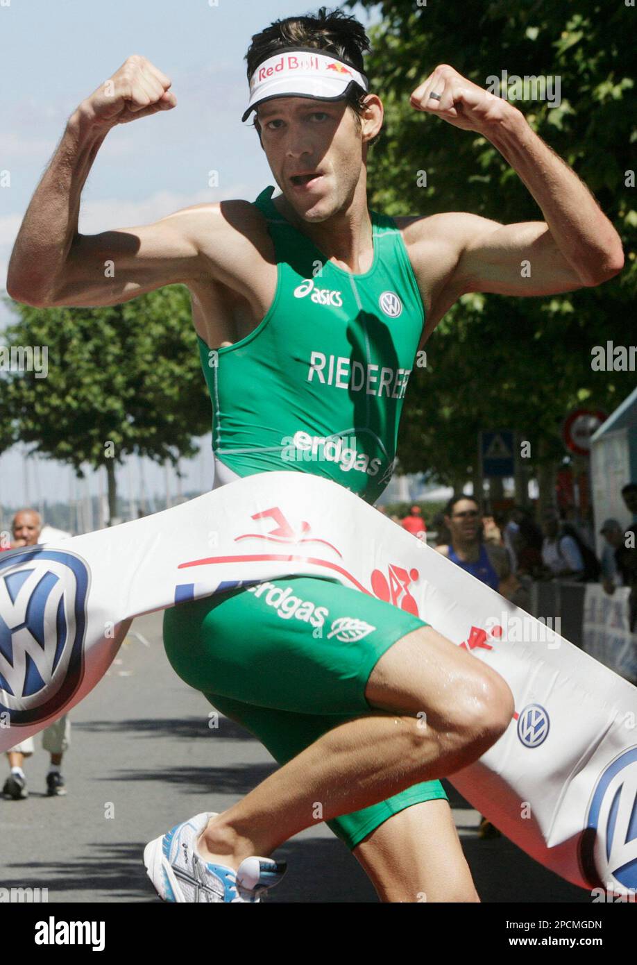 Swiss Sven Riederer, raises his arms after crossing the finish line to ...