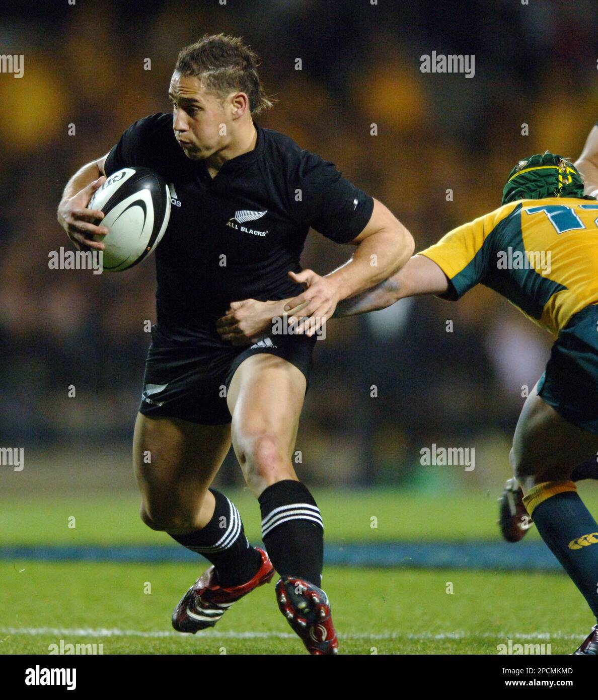 New Zealand All Blacks Luke McAlister slips the tackle of Australian ...