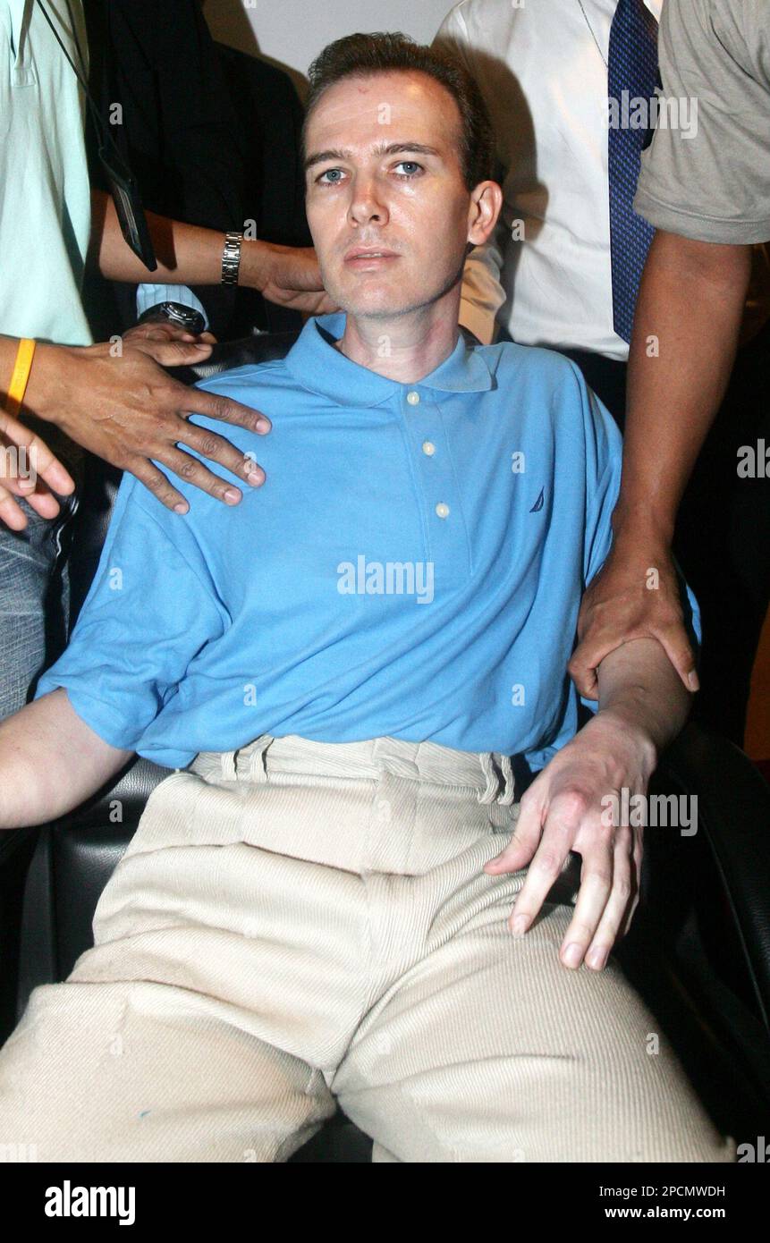 American John Mark Karr is surrounded by plainclothes police officers ...