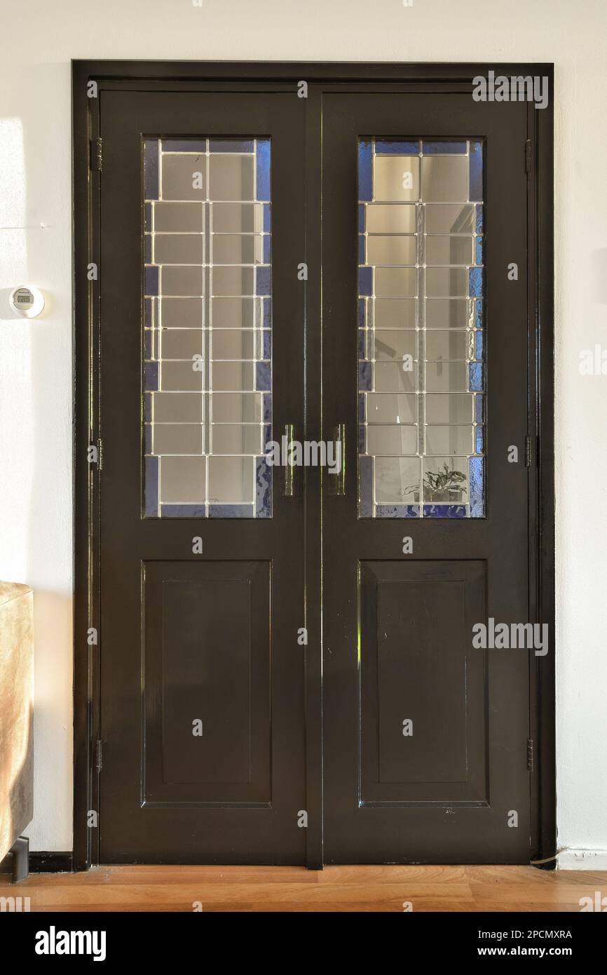 two black doors with glass panels on the top and bottom, in an entry ...
