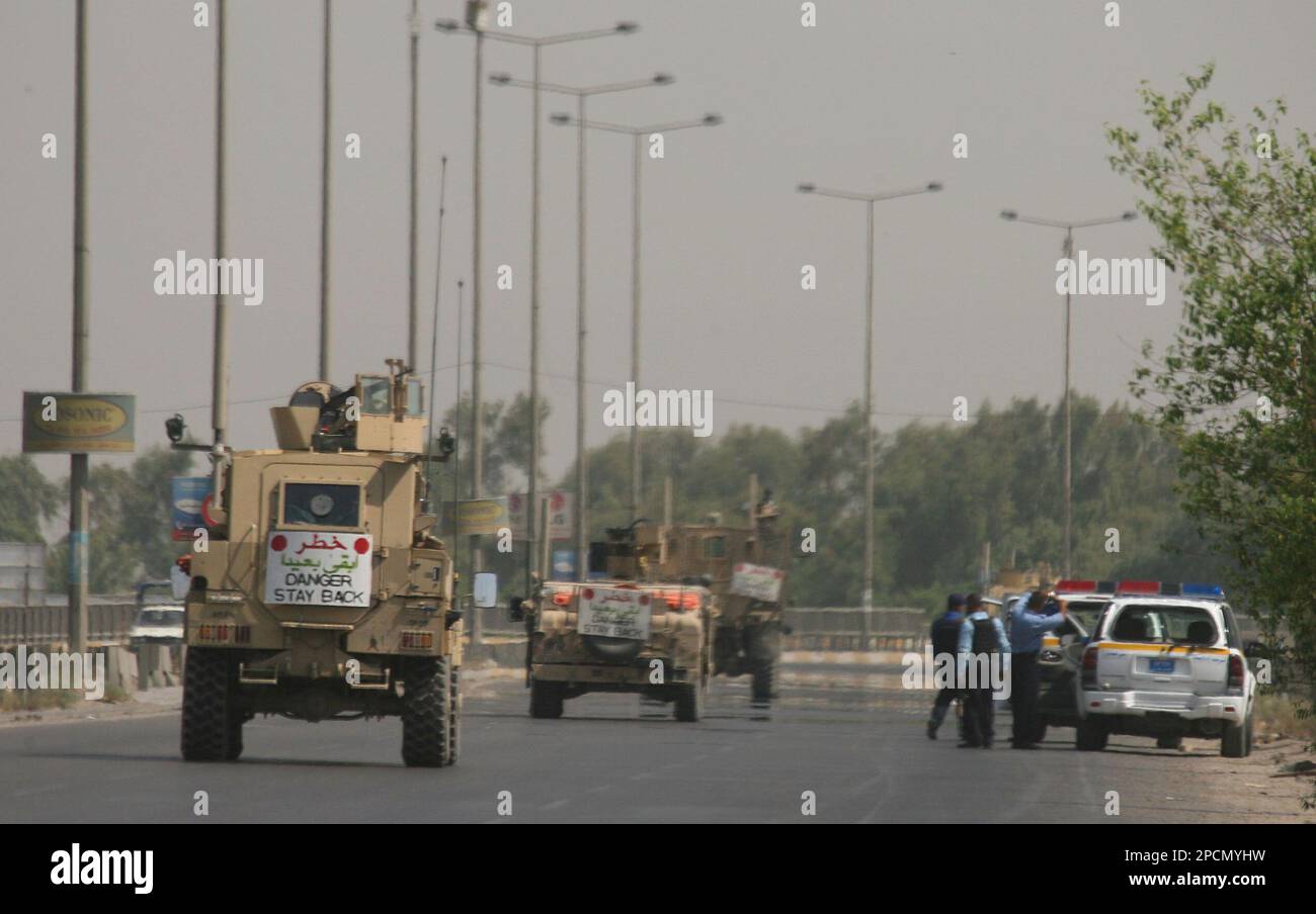 U.S. vehicles travel in a convoy down a main highway leading to western ...