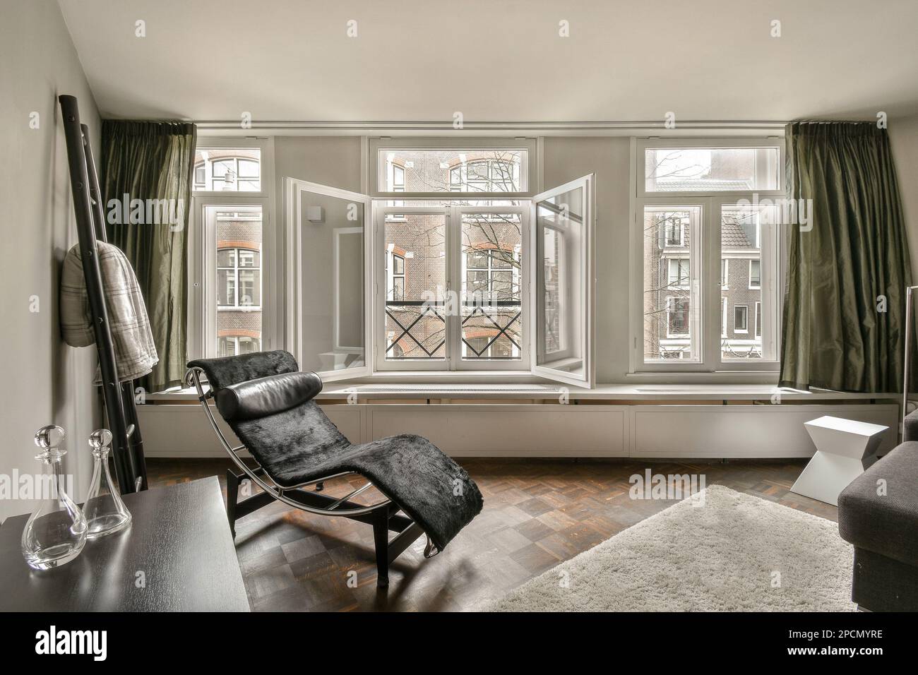 a living room with a large window and chair in front of the window ...