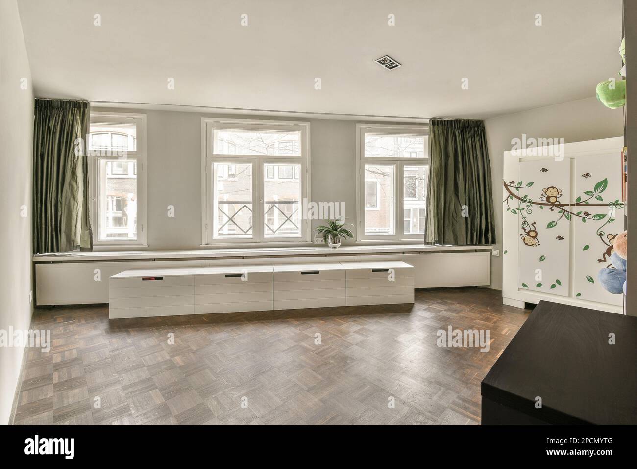 a living room with wood flooring and large windows that look out onto ...