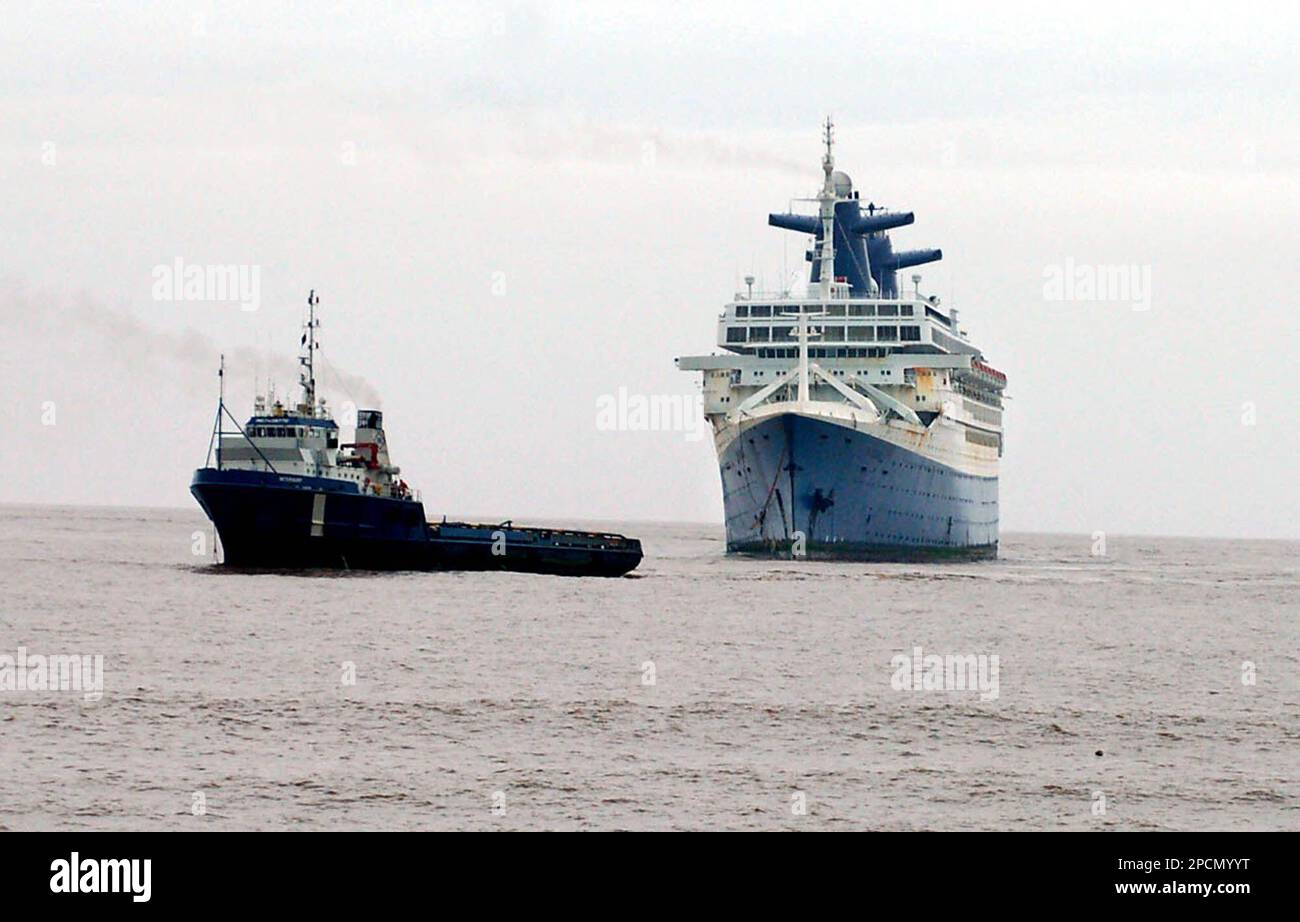 A tugboat pulls ocean liner 'Blue Lady', formerly known as the SS ...