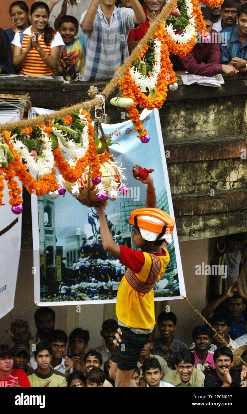 People cheer as a devotee of Hindu God Krishna standing atop a human ...