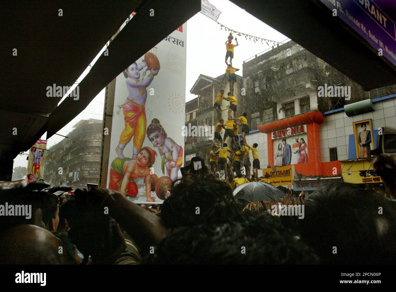 Crowds watch as devotees of Hindu God Krishna make a human pyramid to ...