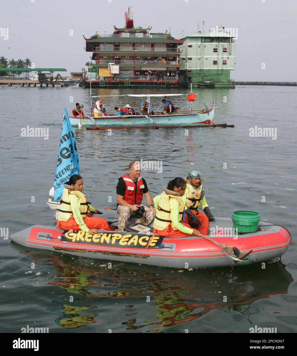 Greenpeace activists scoop debris from the water mostly of plastics ...