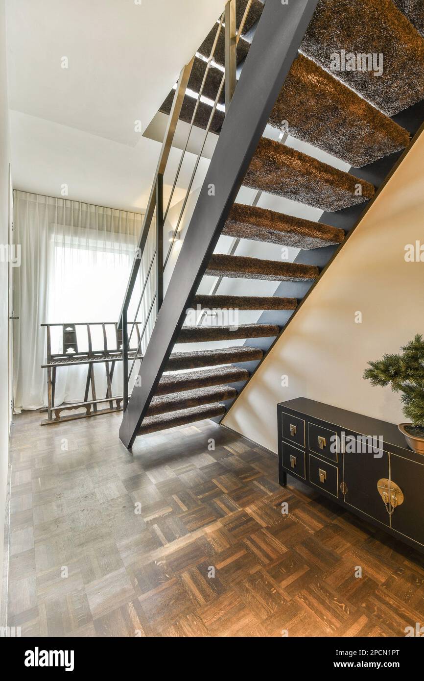 a living room with wood flooring and stairs leading up to the second ...