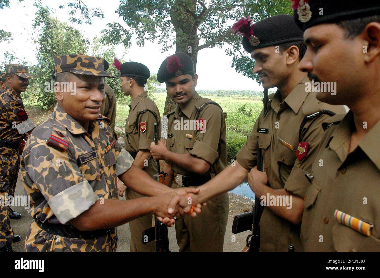 Bangladesh Rifles officers, left, shake hands with Indian Border ...