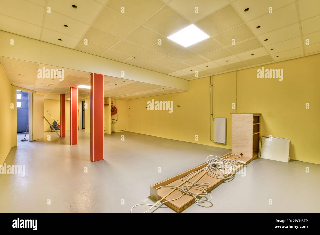 an empty room with no one on the floor, and two red doors in the wall ...