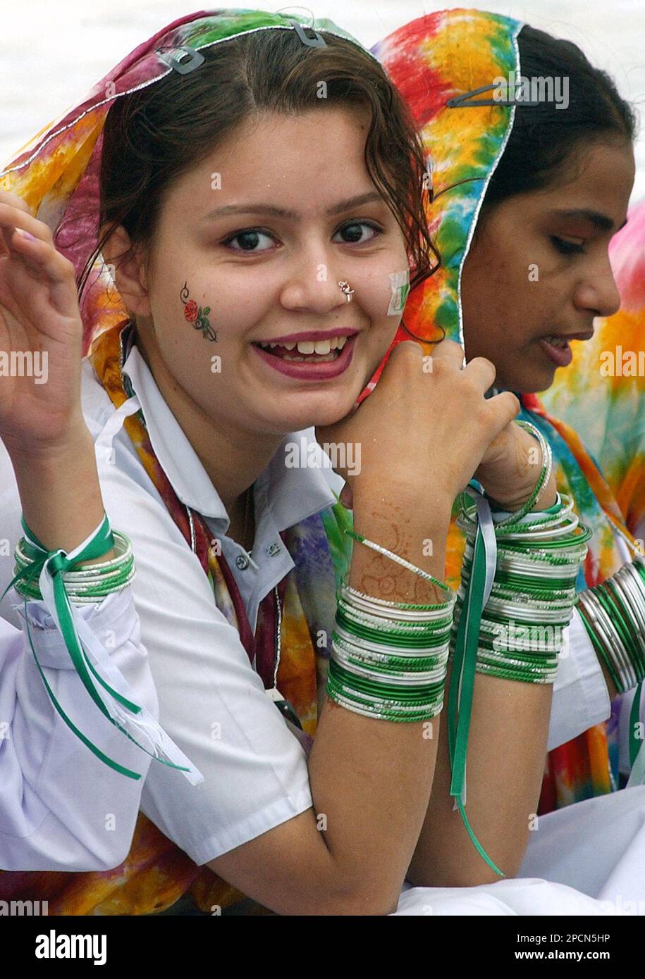 A Pakistani schoolgirl in traditional dress smiles during a ceremony to ...
