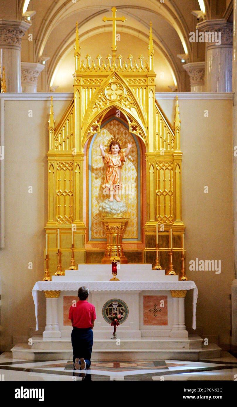 A woman prays inside the church at the Shrine of the Most Blessed ...