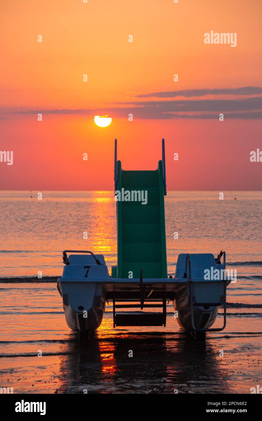 pedal boat on the beach during amazing ocean sunrise Stock Photo - Alamy