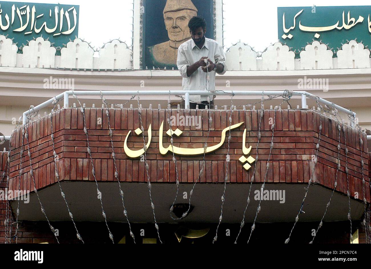 A Pakistan electrician installs decoration lights on an enclosure in ...