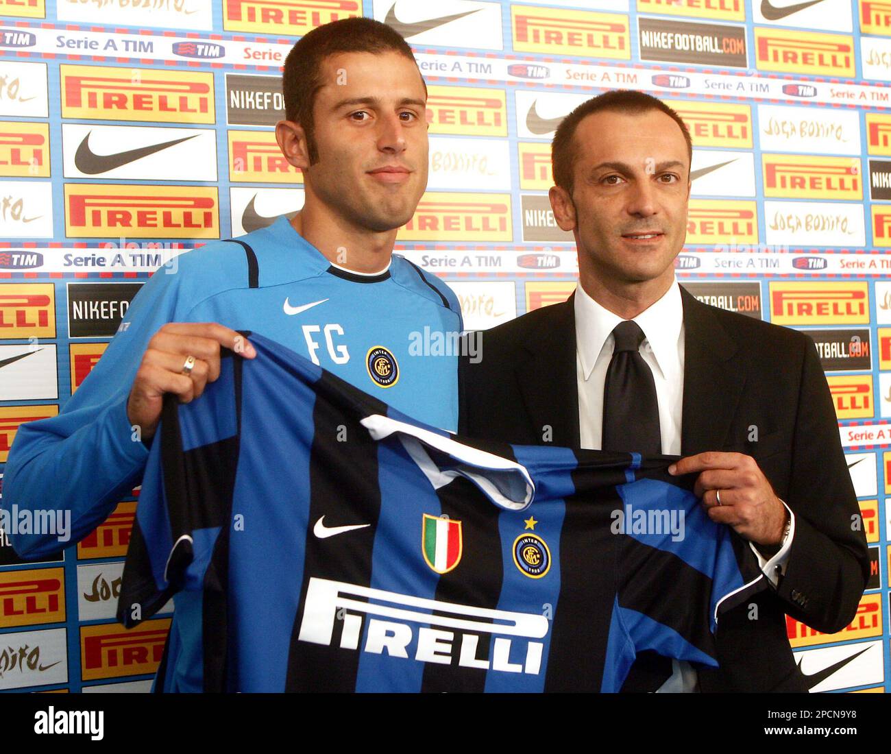 Italy defender Fabio Grosso, left, is flanked by team official Marco ...