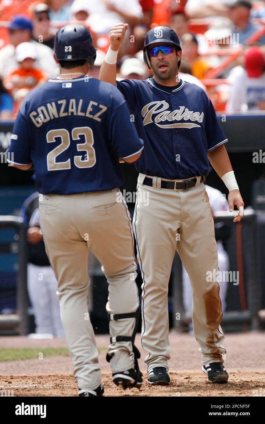 San Diego Padres' Todd Walker, right, greets teammate Adrian Gonzalez at home plate after ...
