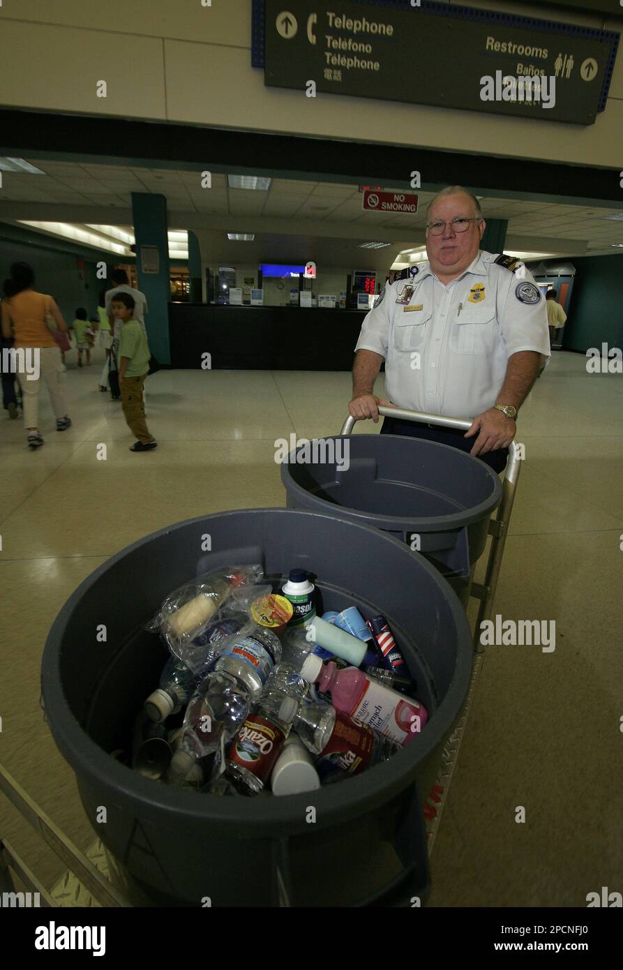 TSA supervisor Emmett Barreca collects trash cans full of liquid and ...