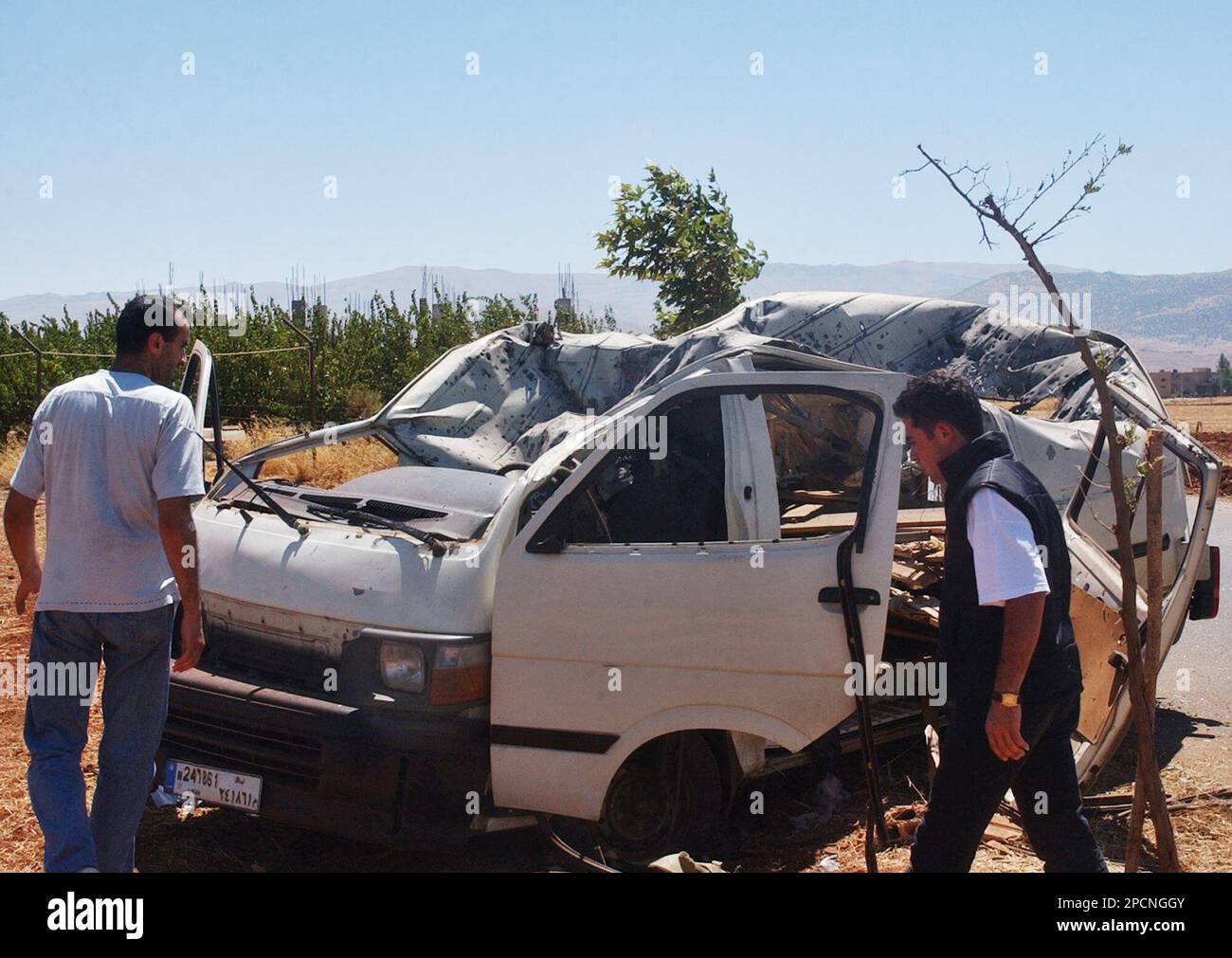 Two Lebanese men look at the wreckage of a vehicle that was targeted by ...