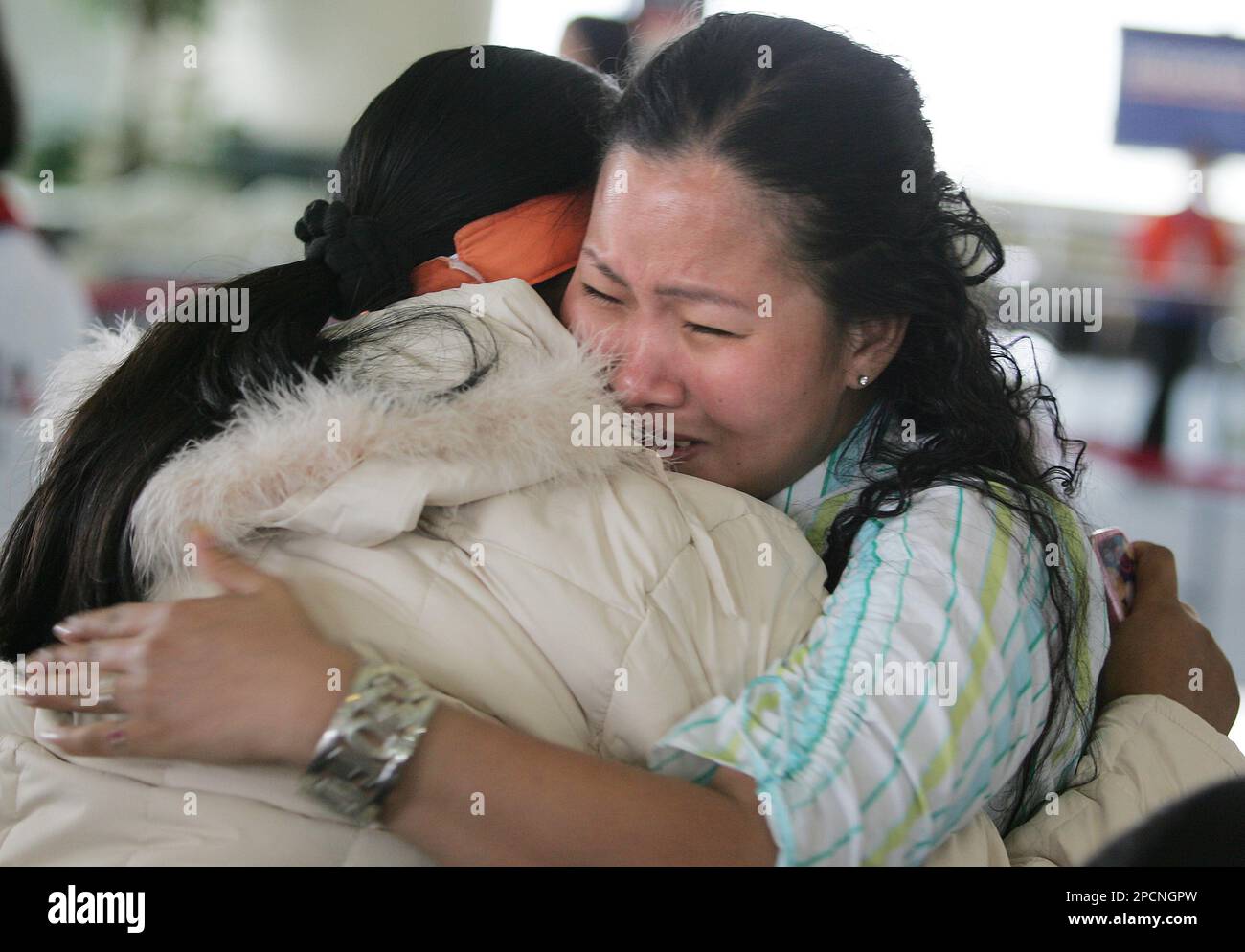 Filipino workers from Lebanon cry while they embrace each other as they ...