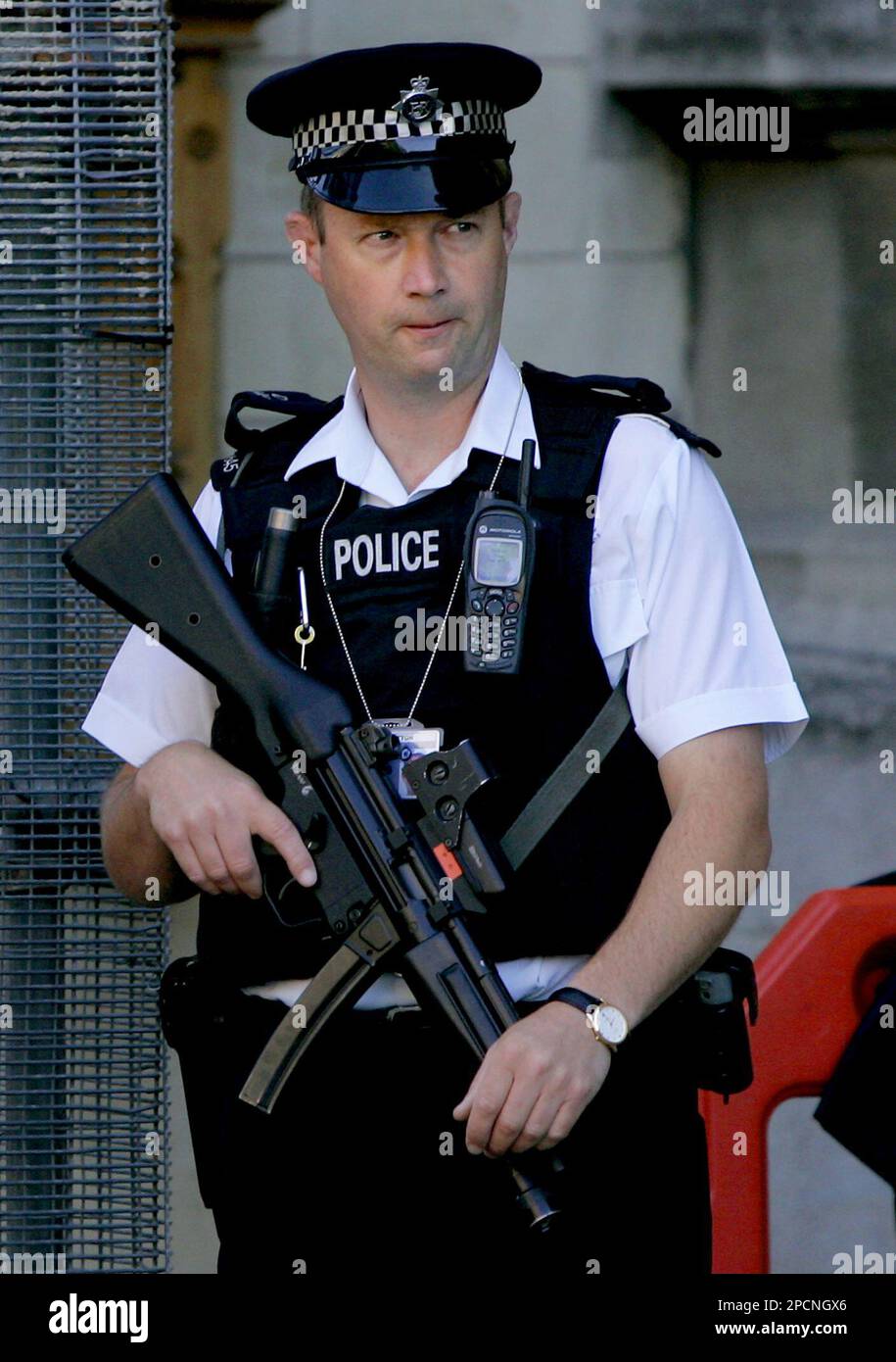 An armed British police officer stands guard outside the Houses of ...