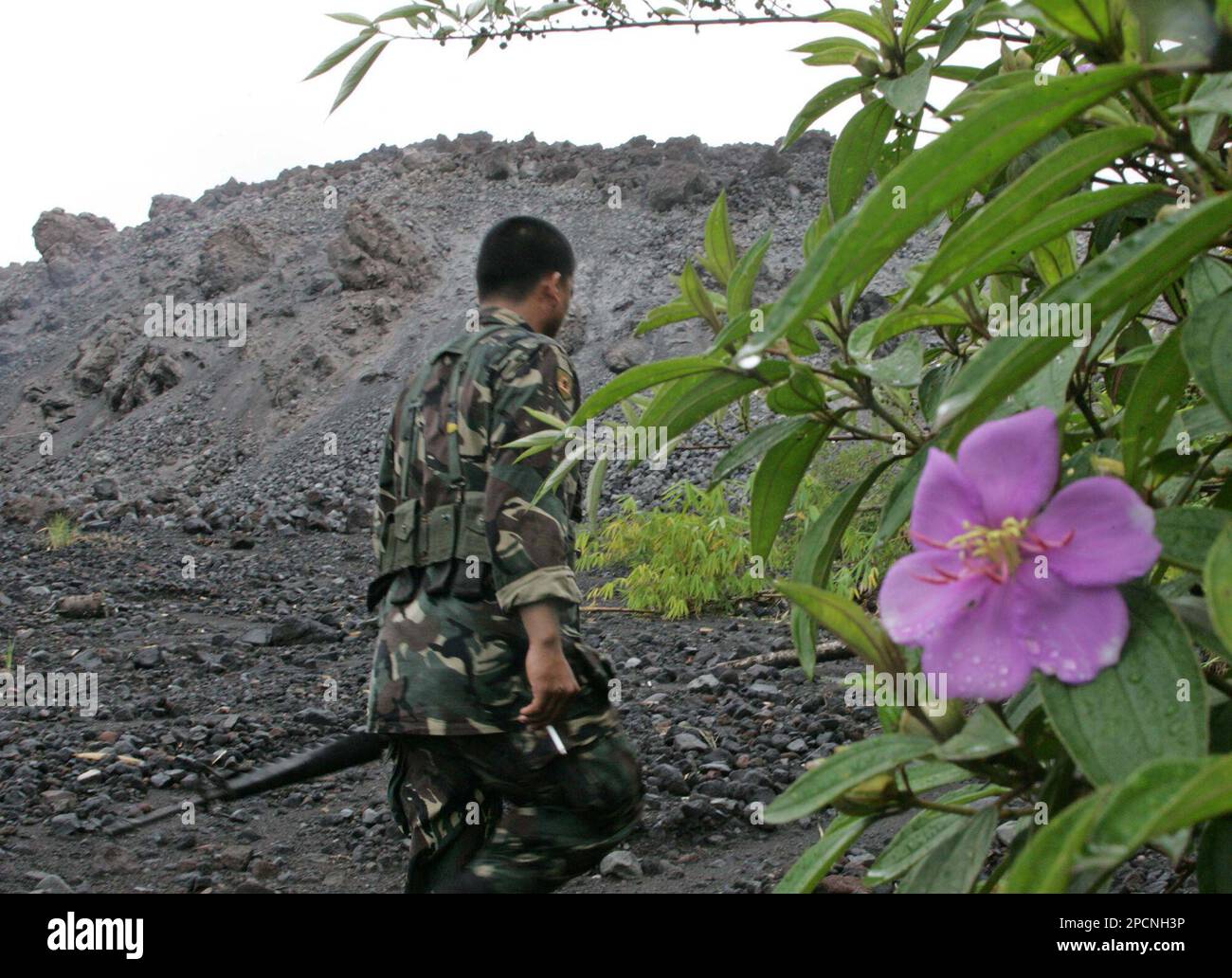 A soldier walks closer to the creeping lava flow of Mayon volcano as it ...
