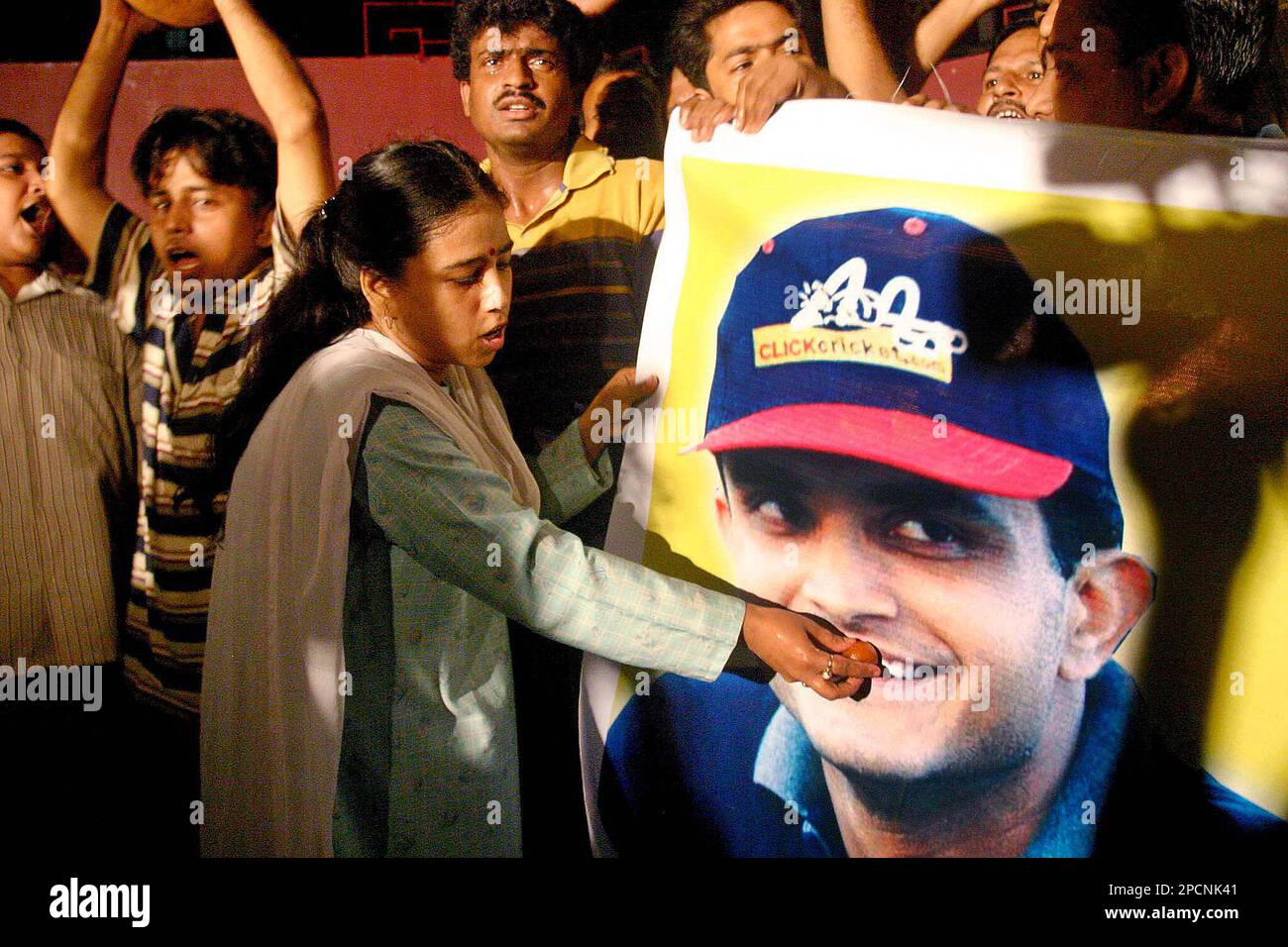 Indian cricket supporters feed sweets to a poster of former India ...