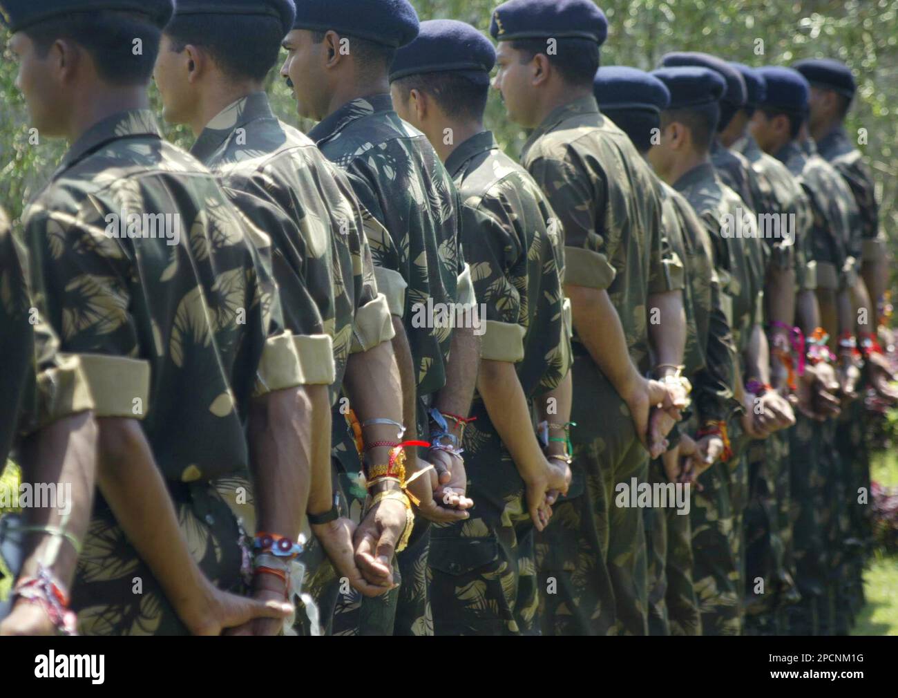 Indian Army soldiers stand with rakhis tied on their wrists after a ...