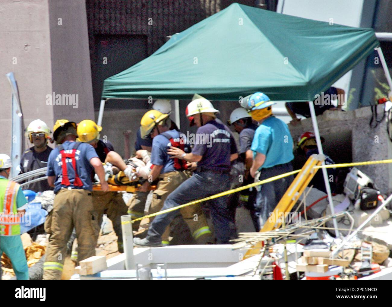 Firefighters and rescuers rush a construction worker to an waiting ...