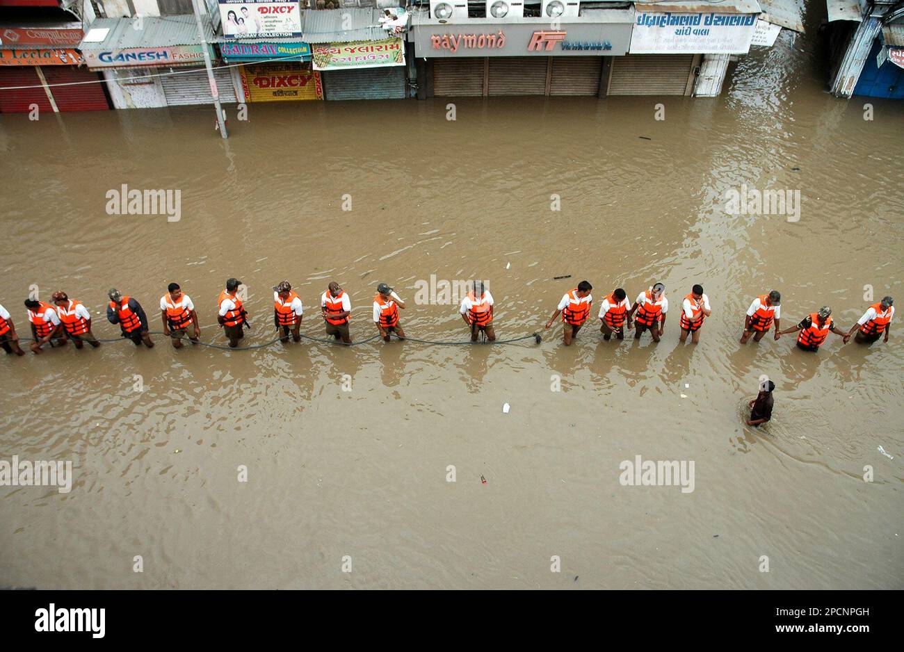 Indian army soldiers stand in line to rescue people stranded in ...