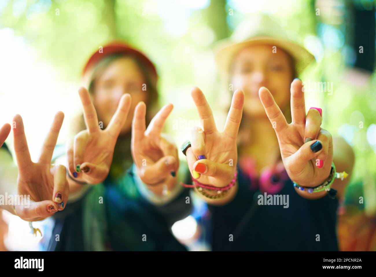 Peace, love and happiness. Three young woman wearing colourful nail ...