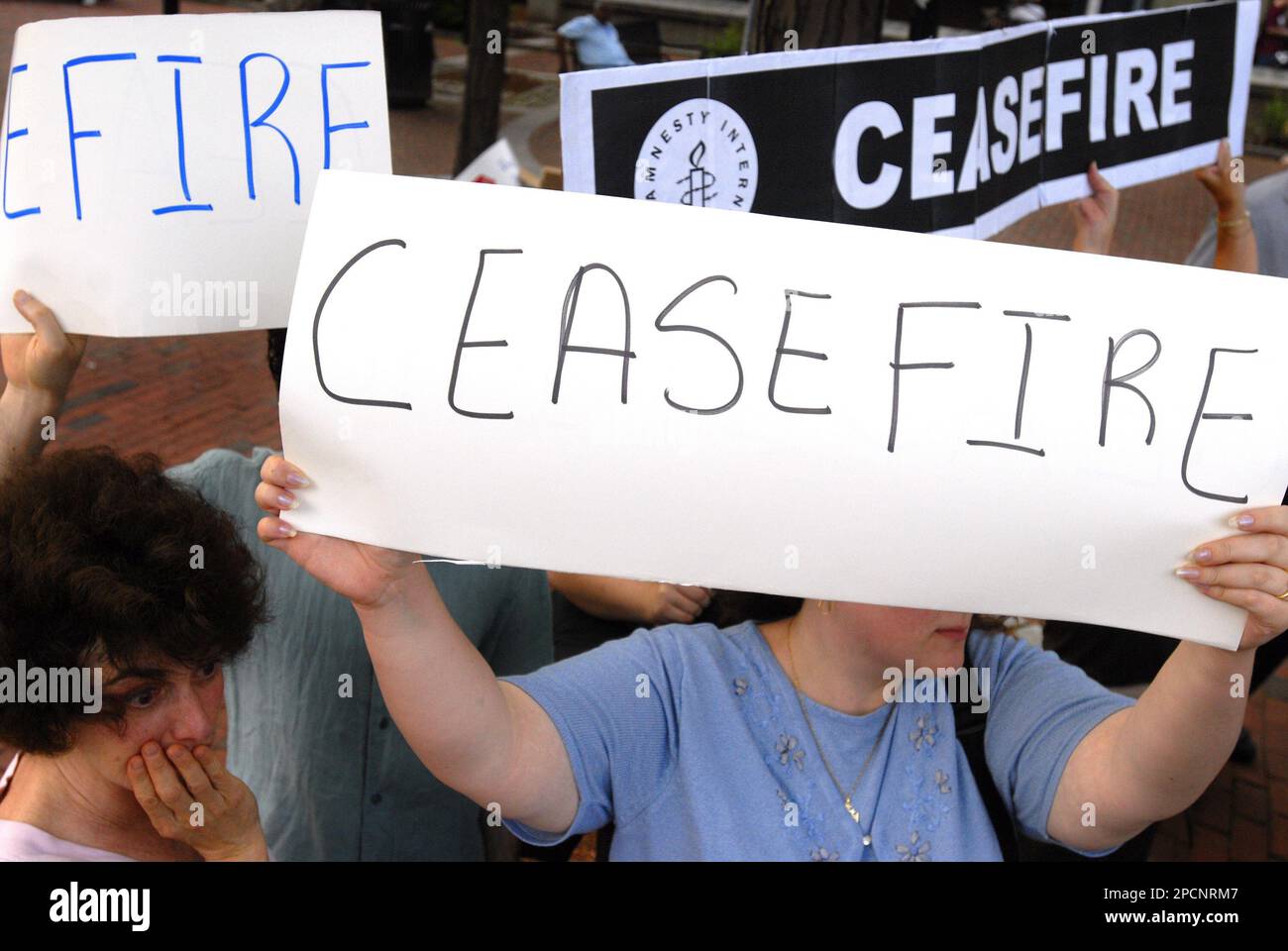 A group of people and members of Amnesty International hold signs in ...