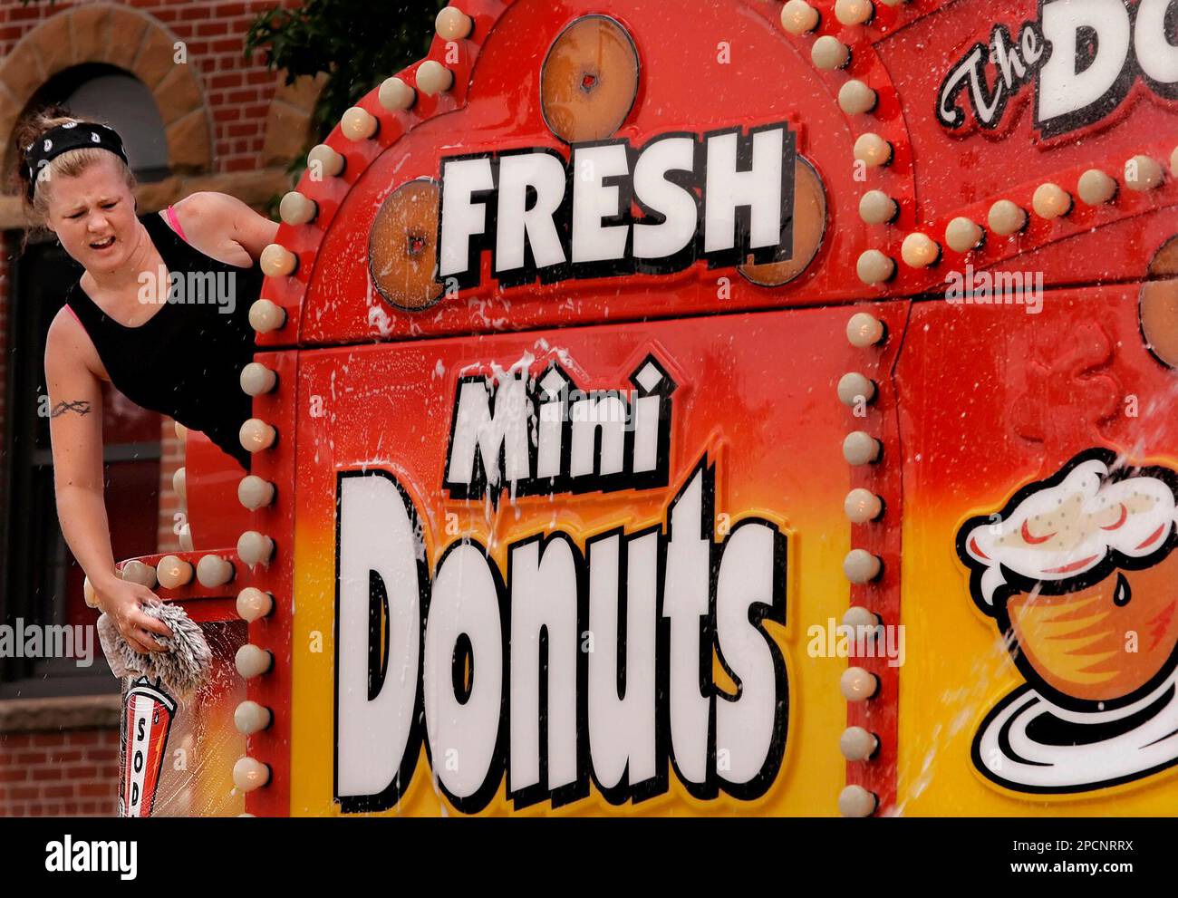 Shawna Hawkins washes down the "The Donut Family" concession sign at ...