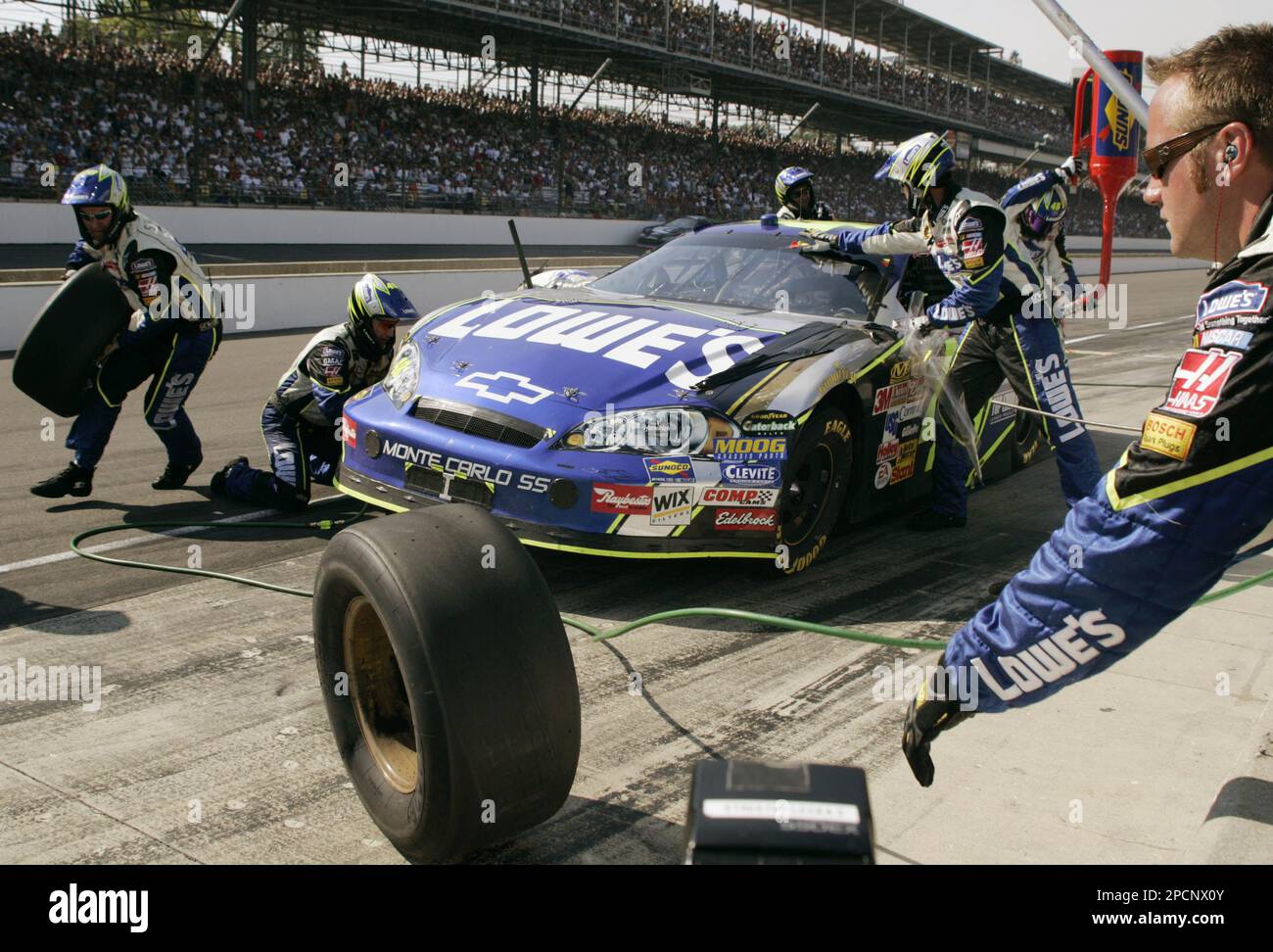 Members of NASCAR driver Jimmie Johnson's crew change tires during a ...