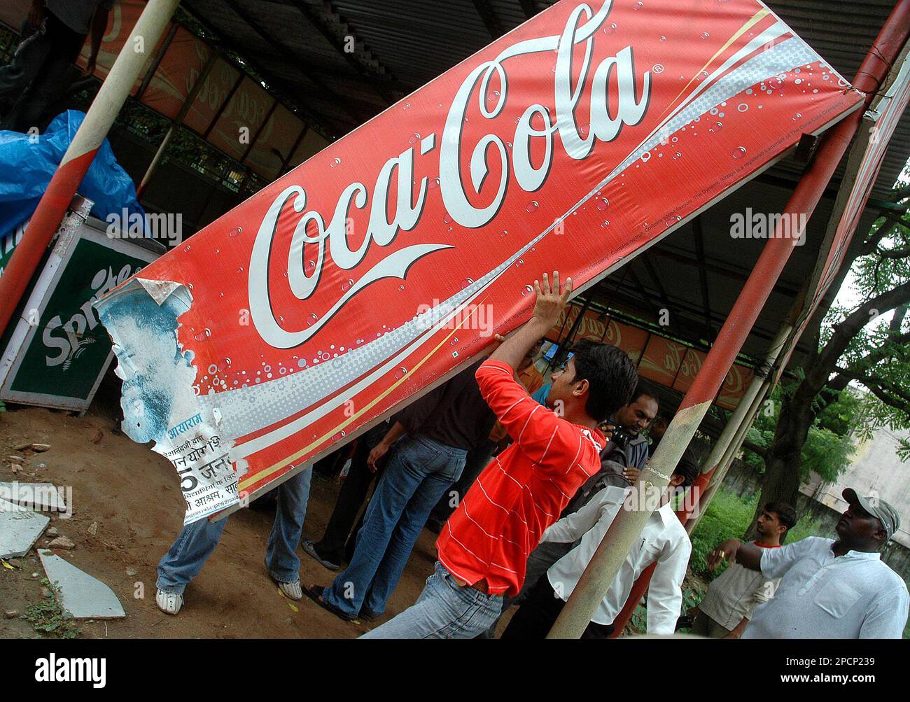 Students pull down a banner of Coca Cola from a cafeteria as they ...