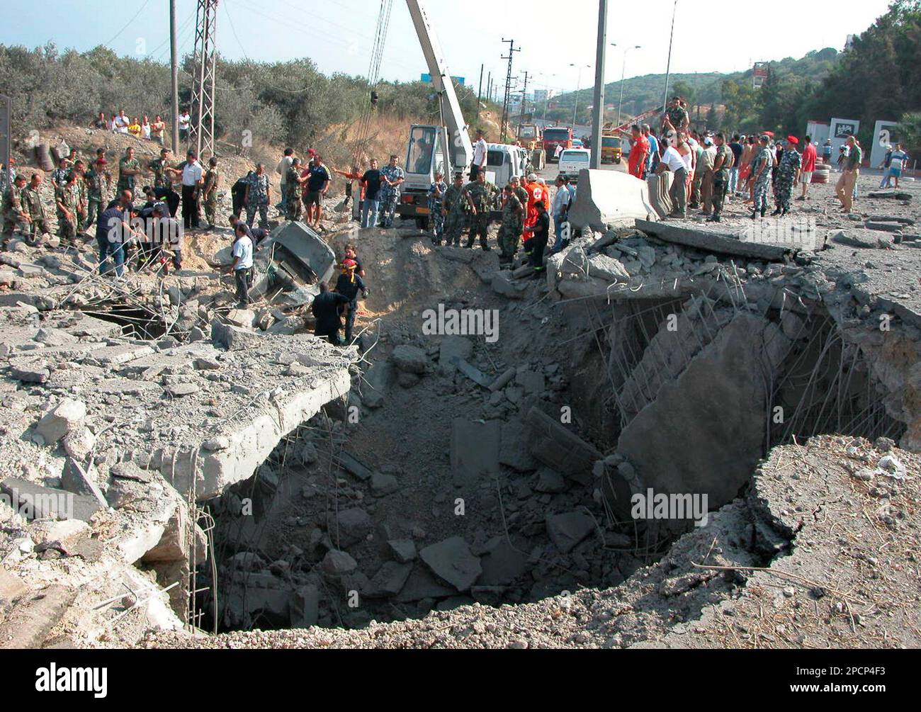 Lebanese rescuers, soldiers and citizens inspect the destroyed bridge ...