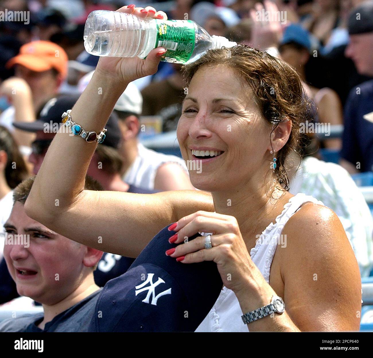 Pam Goetz, of Kingston, N.Y., pours water on her head to cool off as ...