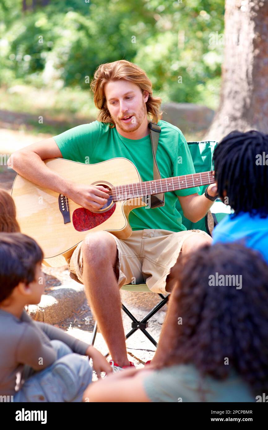 Fresh air and great tunes. A man sitting outside sitting guitar ...
