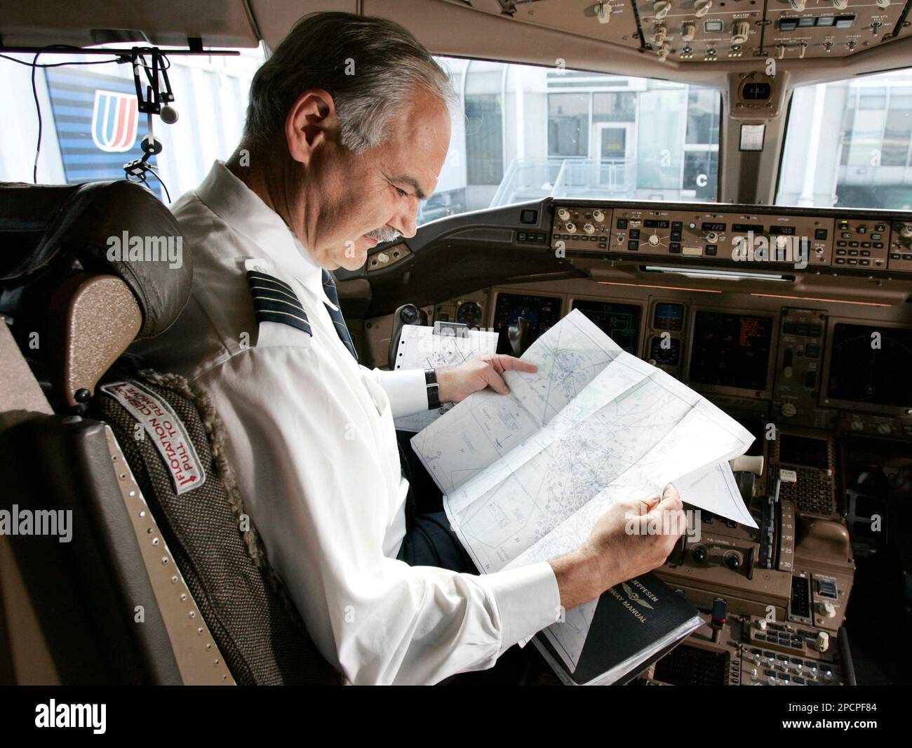 United Airlines pilot Capt. Allan Engelhardt, 59, looks at a map inside ...