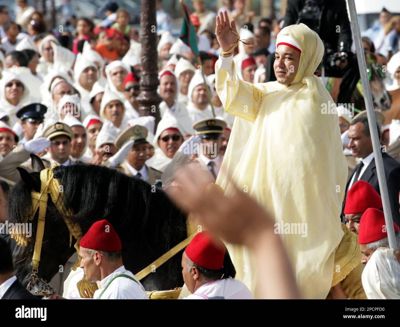 Morocco's King Mohammed VI waves to the crowd as he rides a horse ...