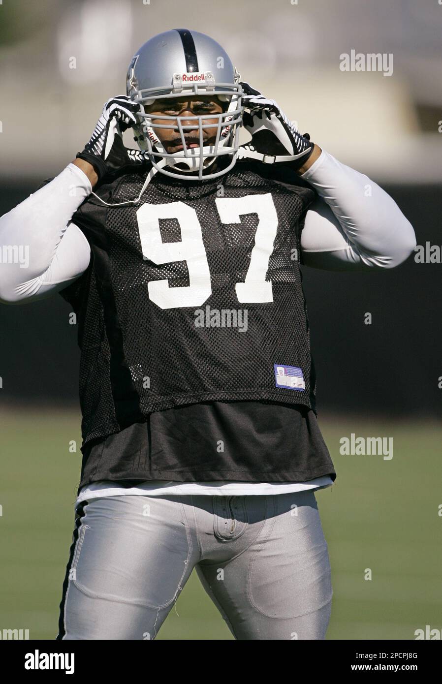 Oakland Raiders defensive lineman Rashad Moore puts on his helmet ...