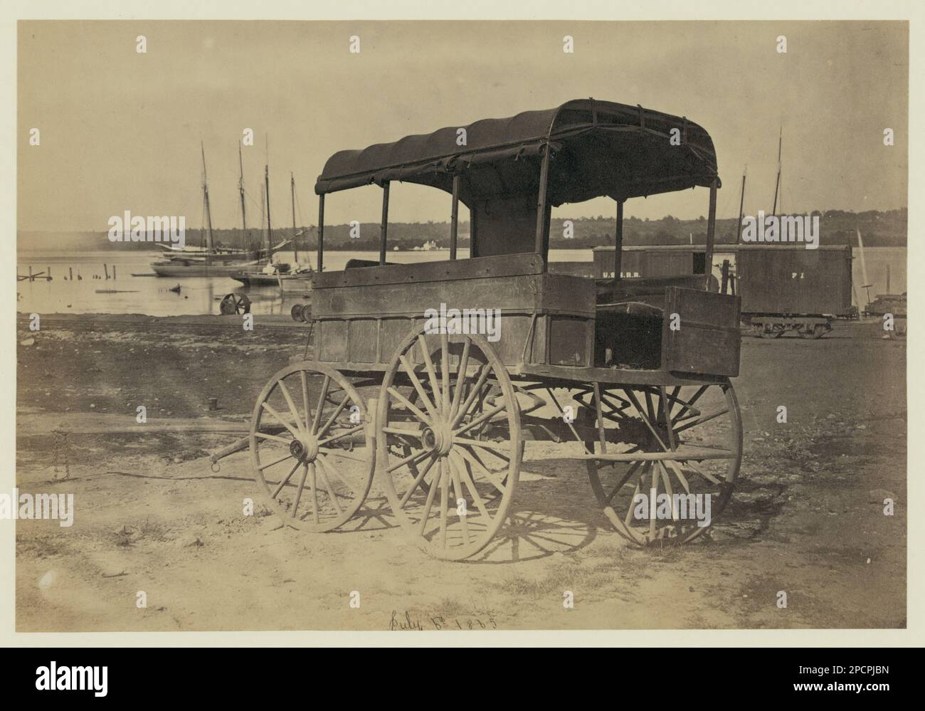 Covered wagon with side curtains rolled up at a military facility ...