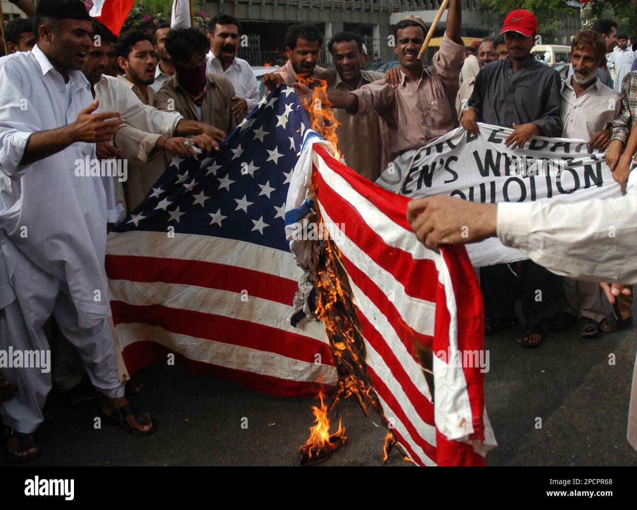 Pakistani protesters burn replicas of Israeli and U.S flags during a ...