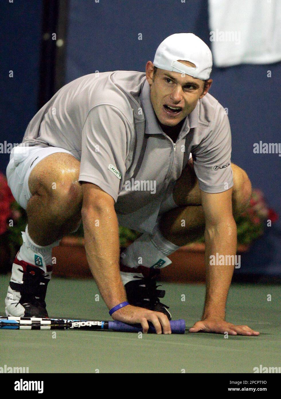 Andy Roddick winces after he appeared to injure his back during his ...