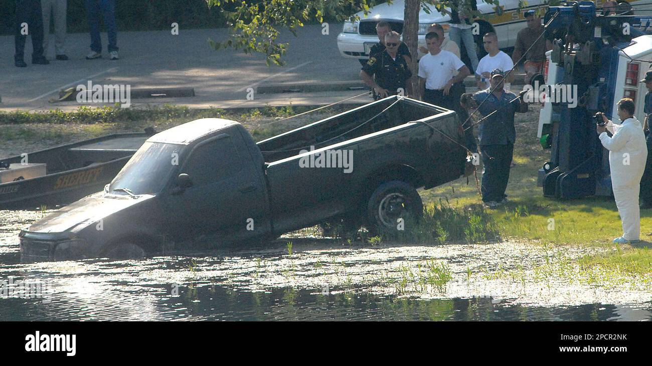 Authorities and divers pull a pickup truck belonging to Ryan Katcher, a ...